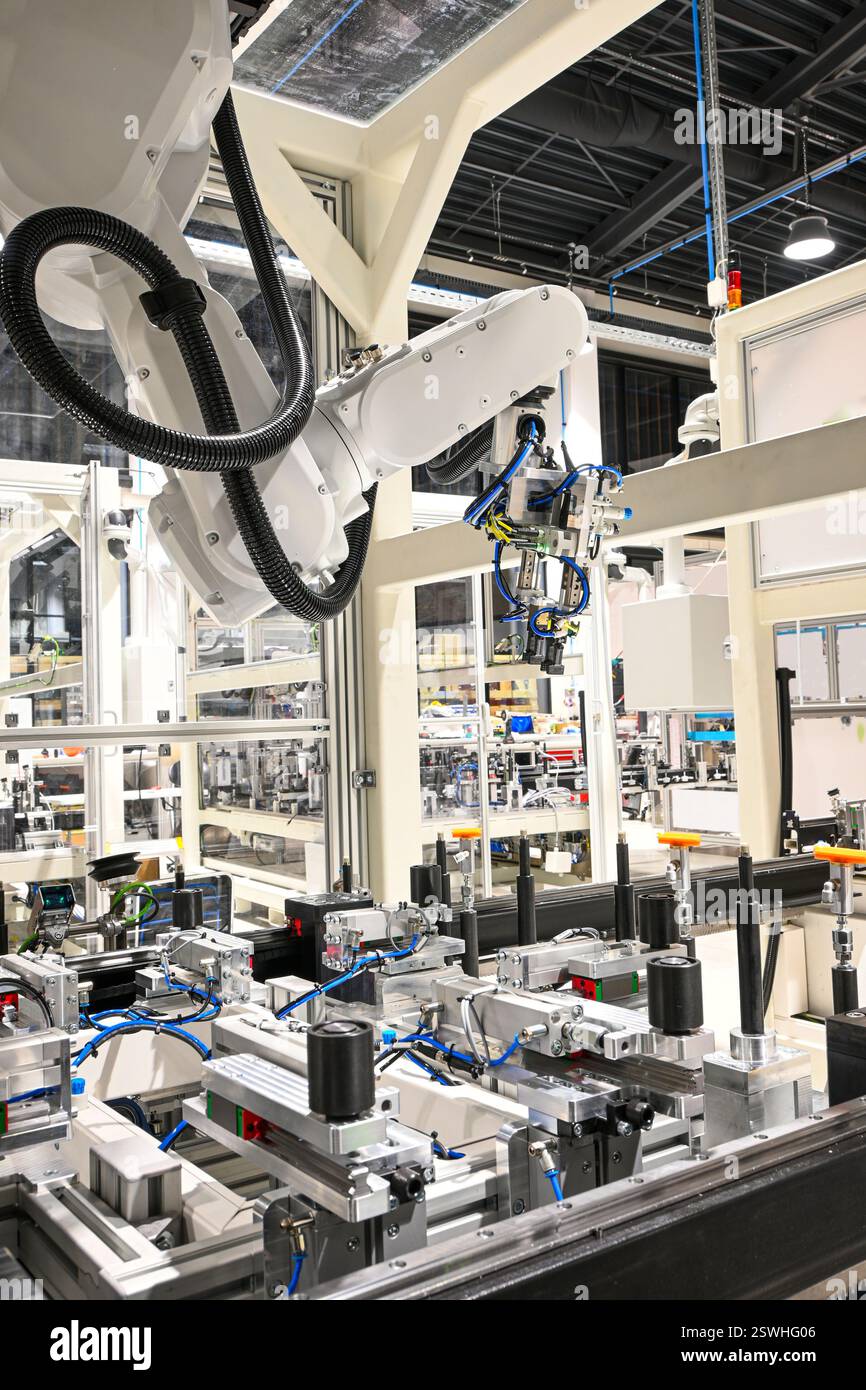 Modern robotic arm performing tasks on an automated production line in a high-tech factory Stock ...