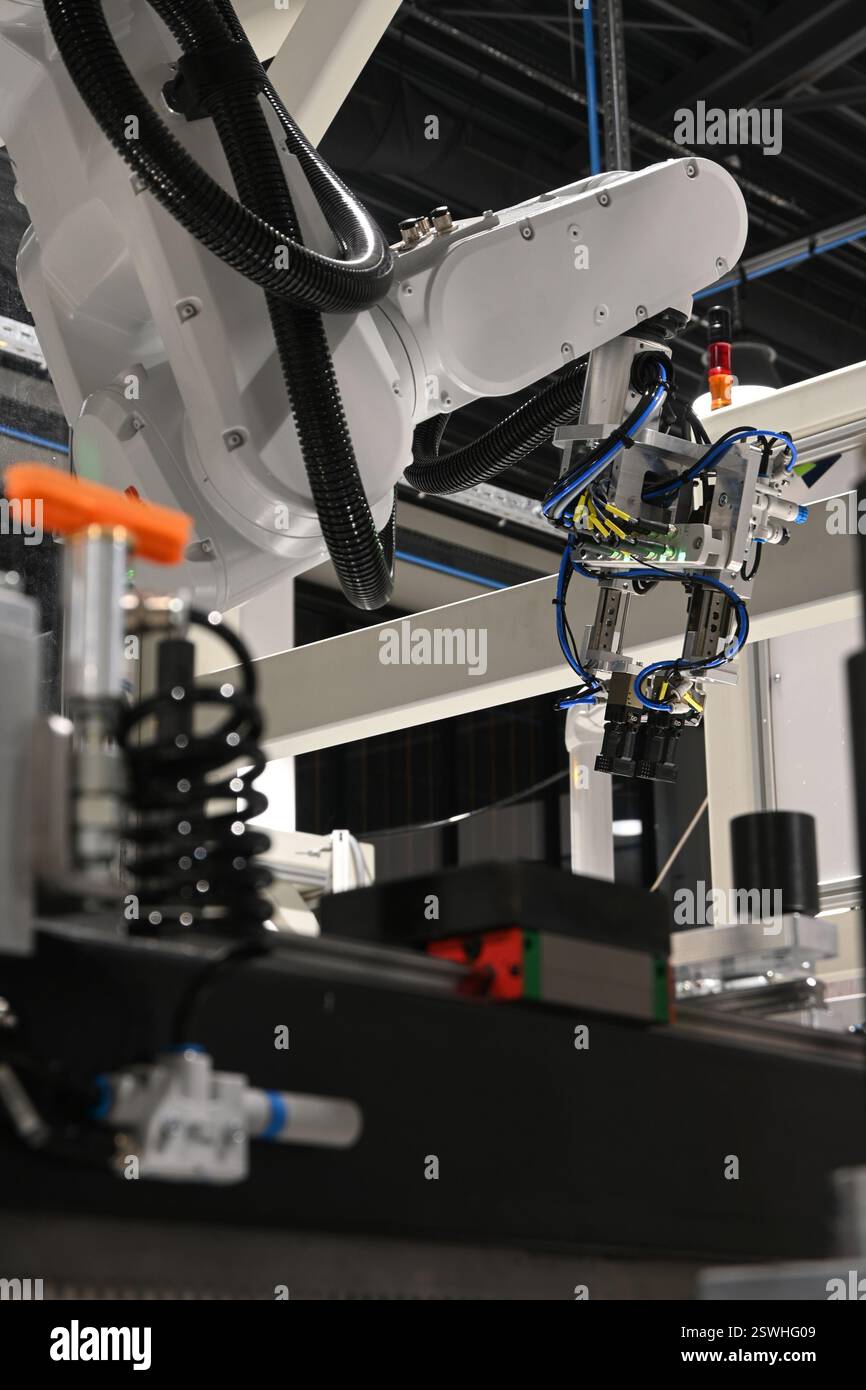 Modern robotic arm performing tasks on an automated production line in a high-tech factory Stock ...