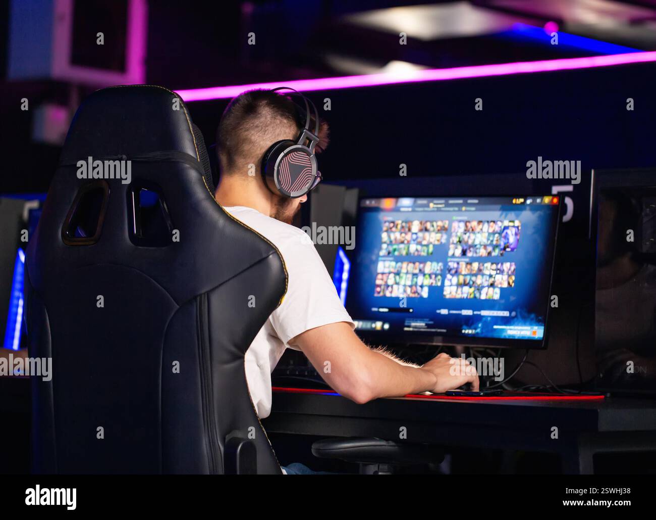 Professional gamer is playing a computer game on PC at cyber club ...