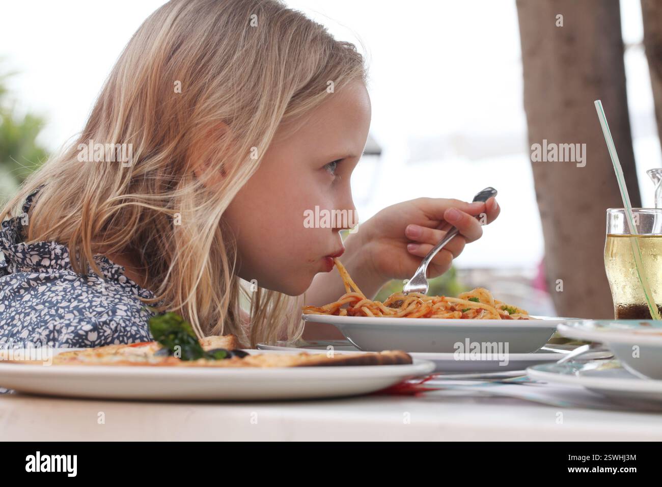 Cute child girl eating Italian spaghetti Stock Photo - Alamy