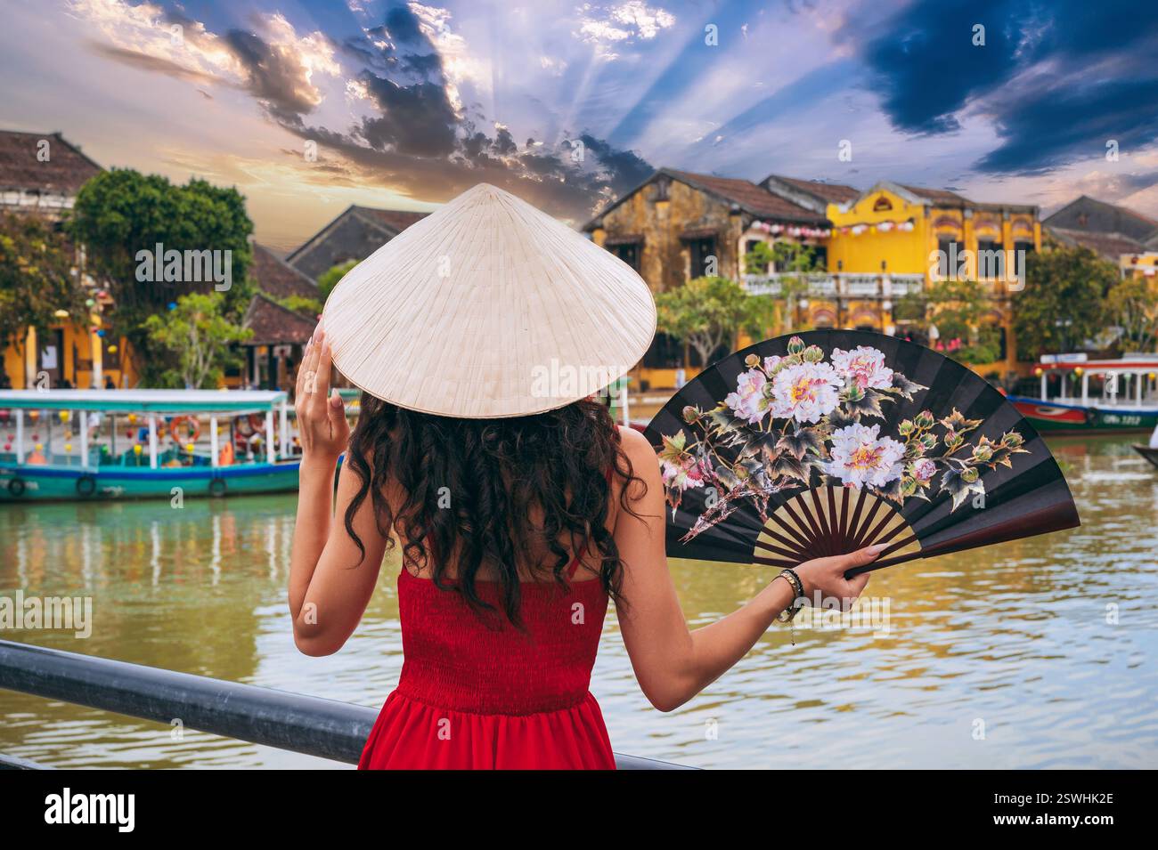 back of woman tourist traveler in a Vietnamese hat with a fan on a ...