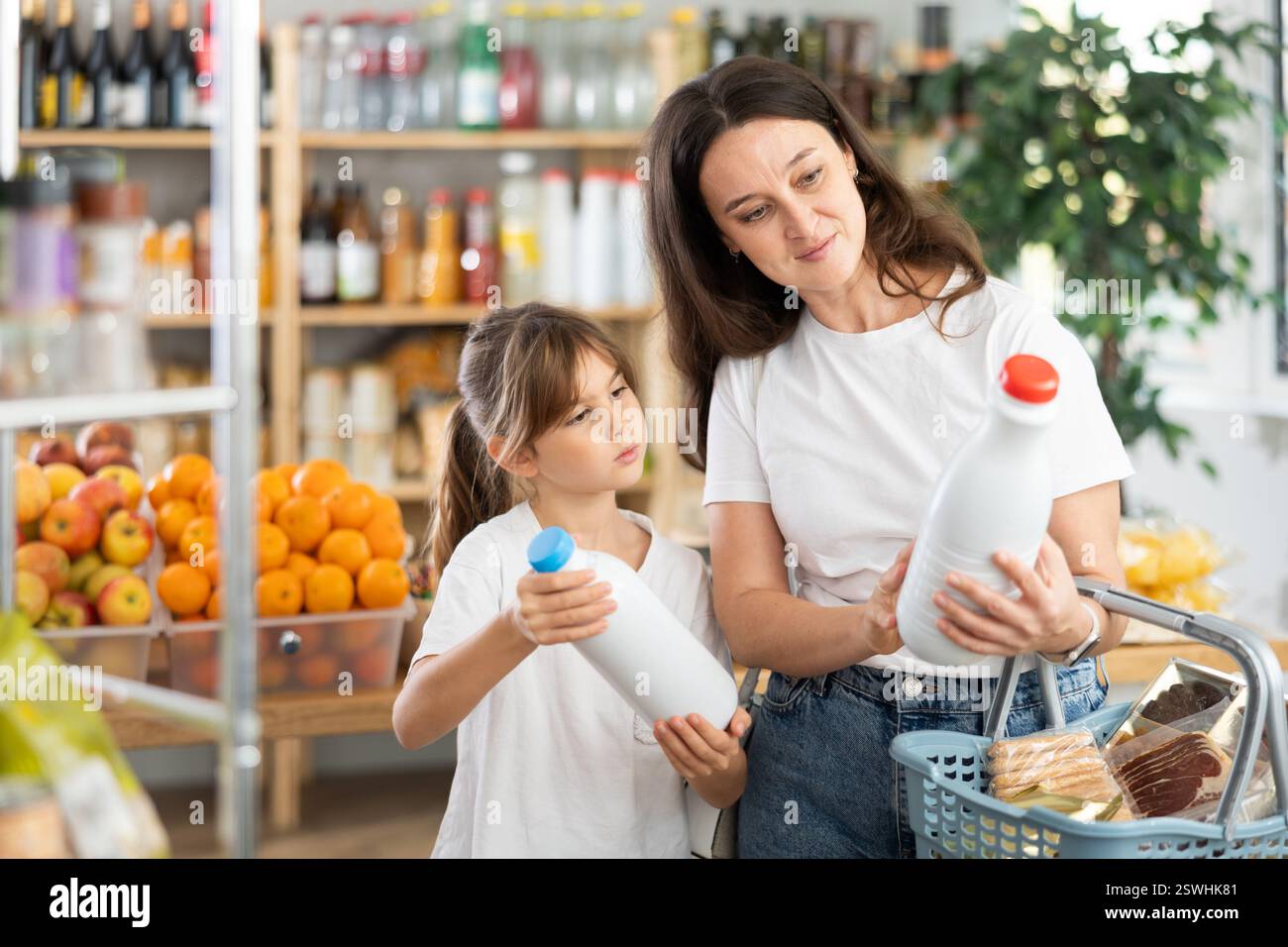 Checking expiration date of milk - mother and daughter checking qr code ...