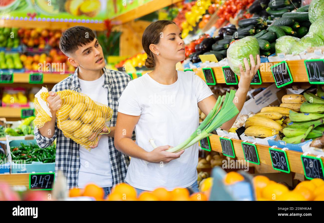 Positive couple choosing foods in fruit and vegetable section of ...