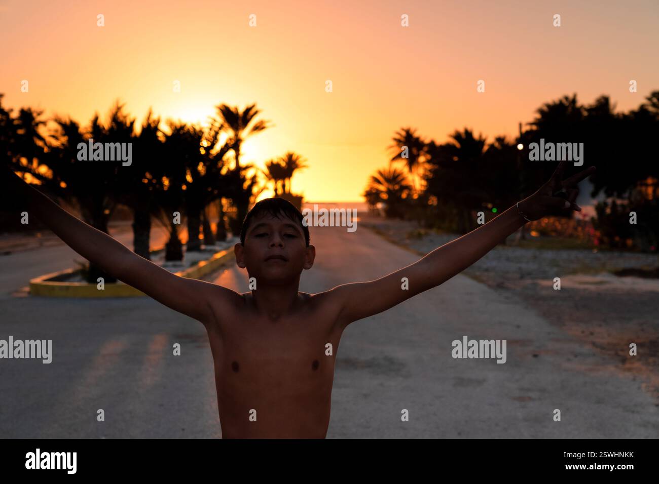 Silhouette of a boy at sunset on the seashore. Children in poverty in ...