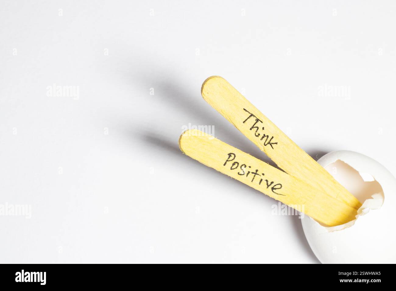 close up of a hand written message on a popsicle stick stating think ...