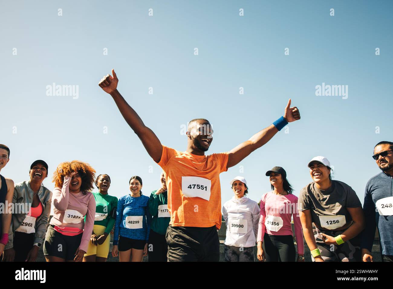 A joyous runner raises his arms in triumph as he celebrates finishing a ...