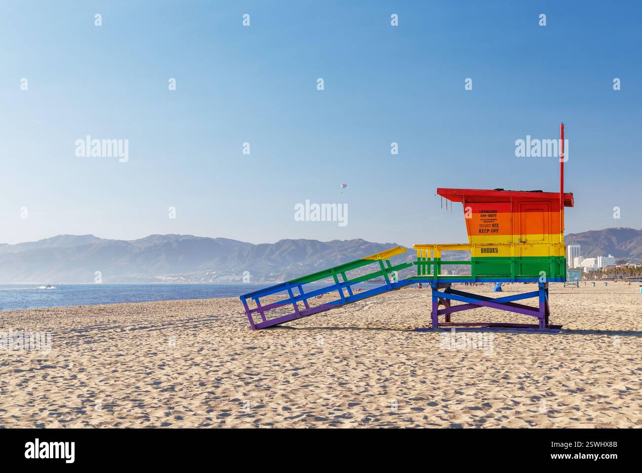 Vibrant lifeguard tower painted in LGBTQ rainbow colors, standing ...