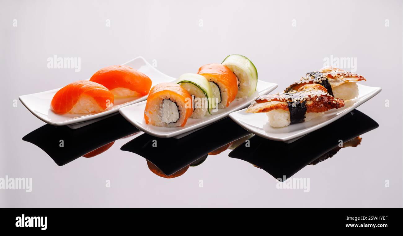 Assorted sushi and maki rolls beautifully arranged on plates, featuring ...
