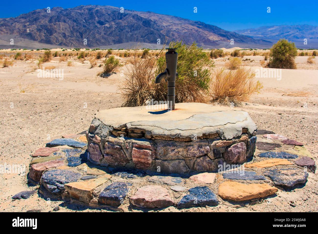 Well is situated in the middle of a desert, surrounded by a circle of ...