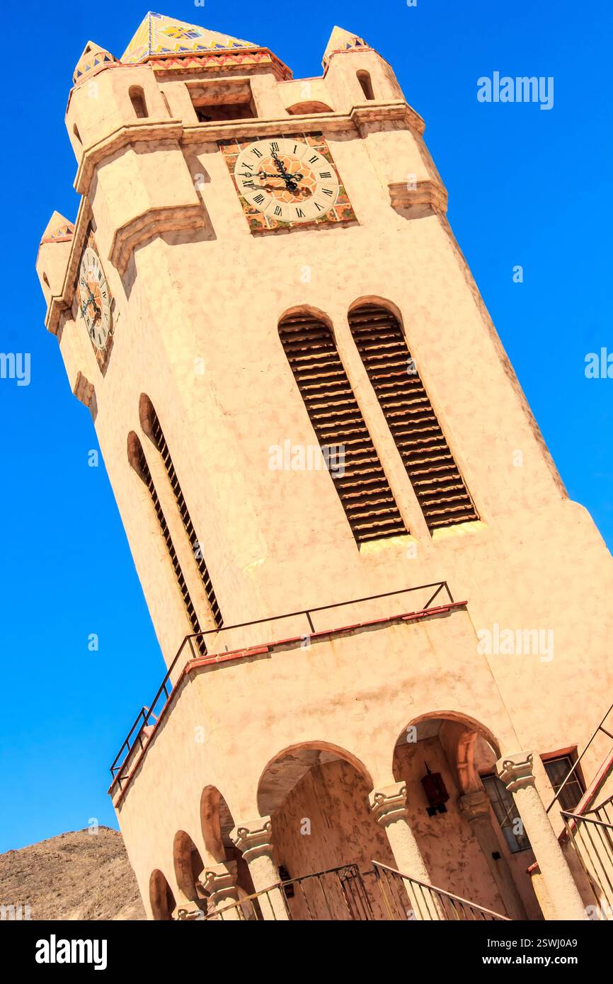 Tall clock tower with a clock on the front. The clock is set at 12:00 ...