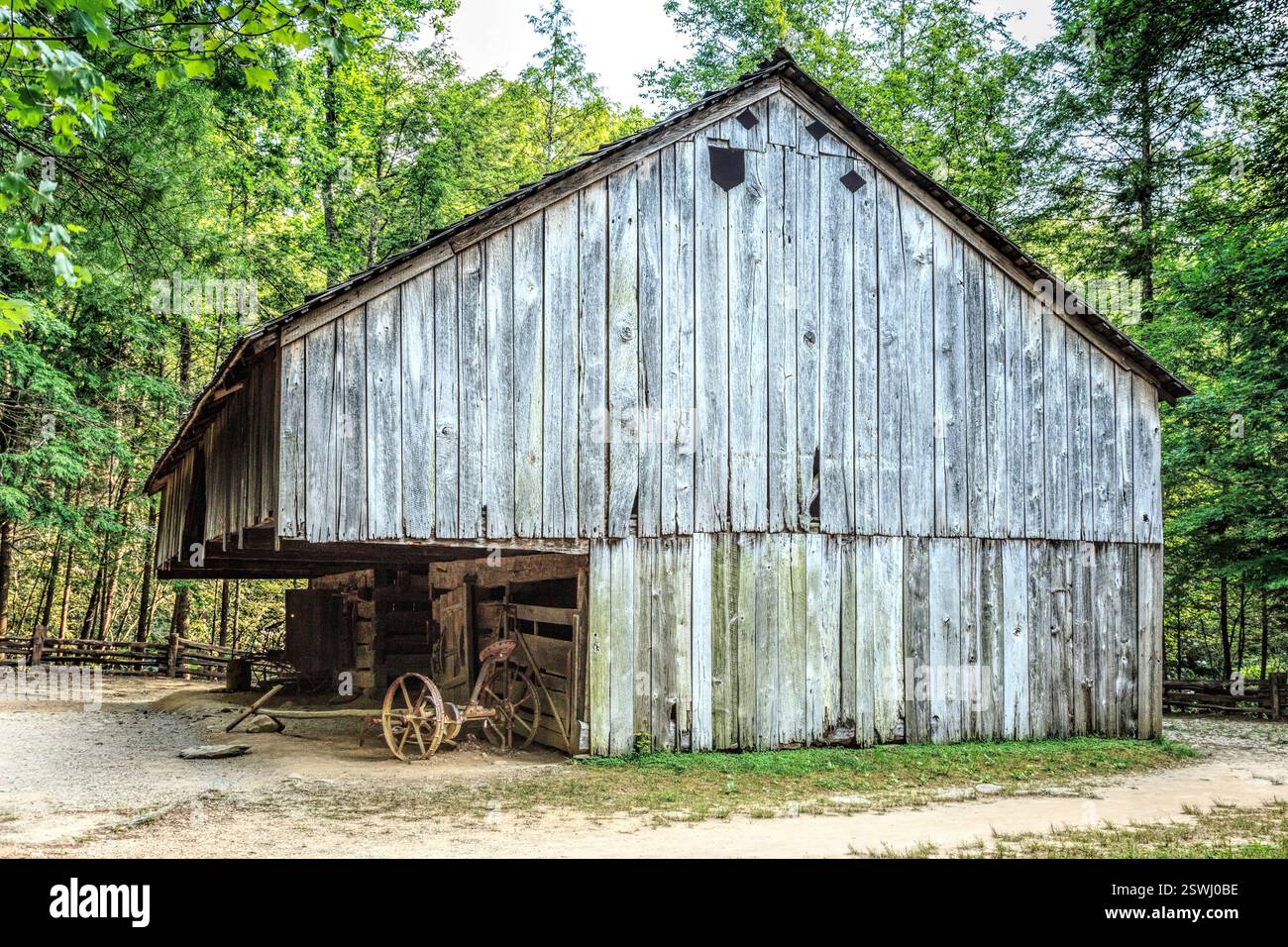 Barn with a wheel on the ground. The barn is old and has a lot of wood ...