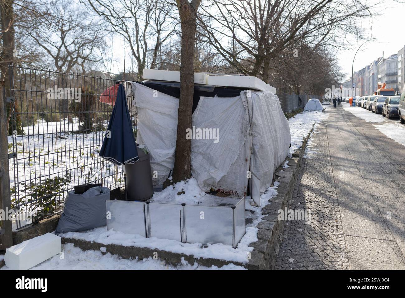 A self-made shelter for a homeless person on the side of the sidewalk ...
