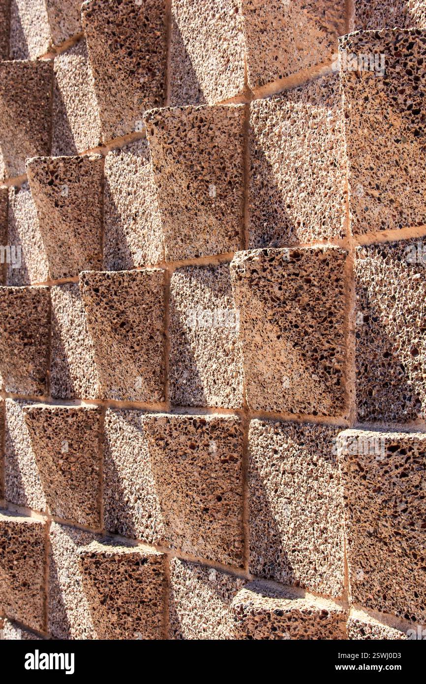 Wall made of bricks with a pattern of squares. The wall is brown and ...