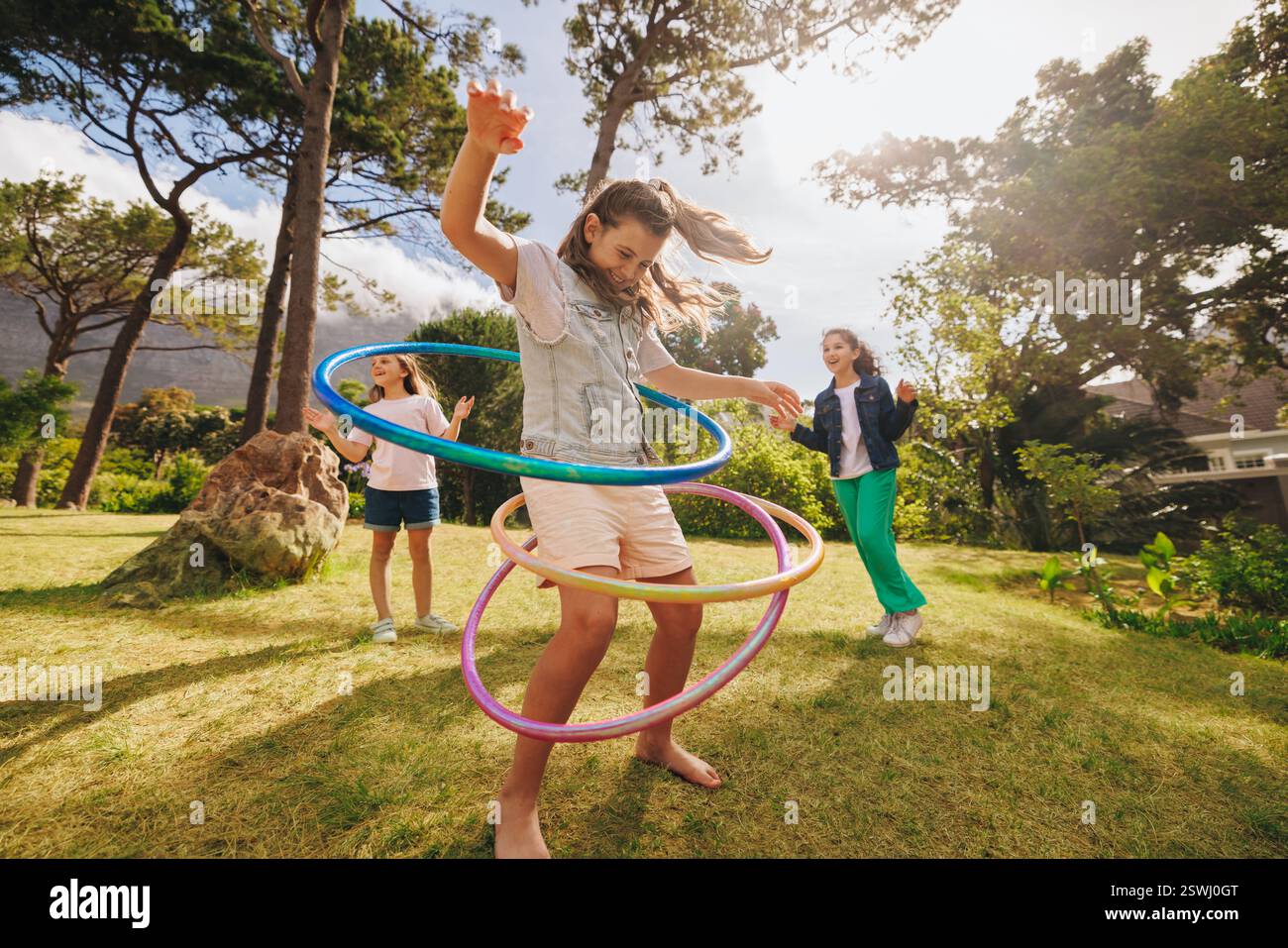 A happy group of children playing outdoors in a scenic park, spinning ...
