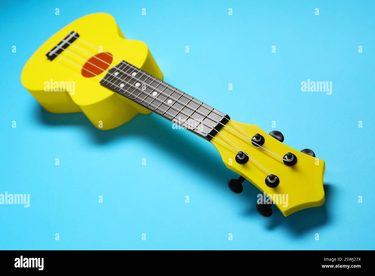 One ukulele on light blue background, closeup. String musical ...