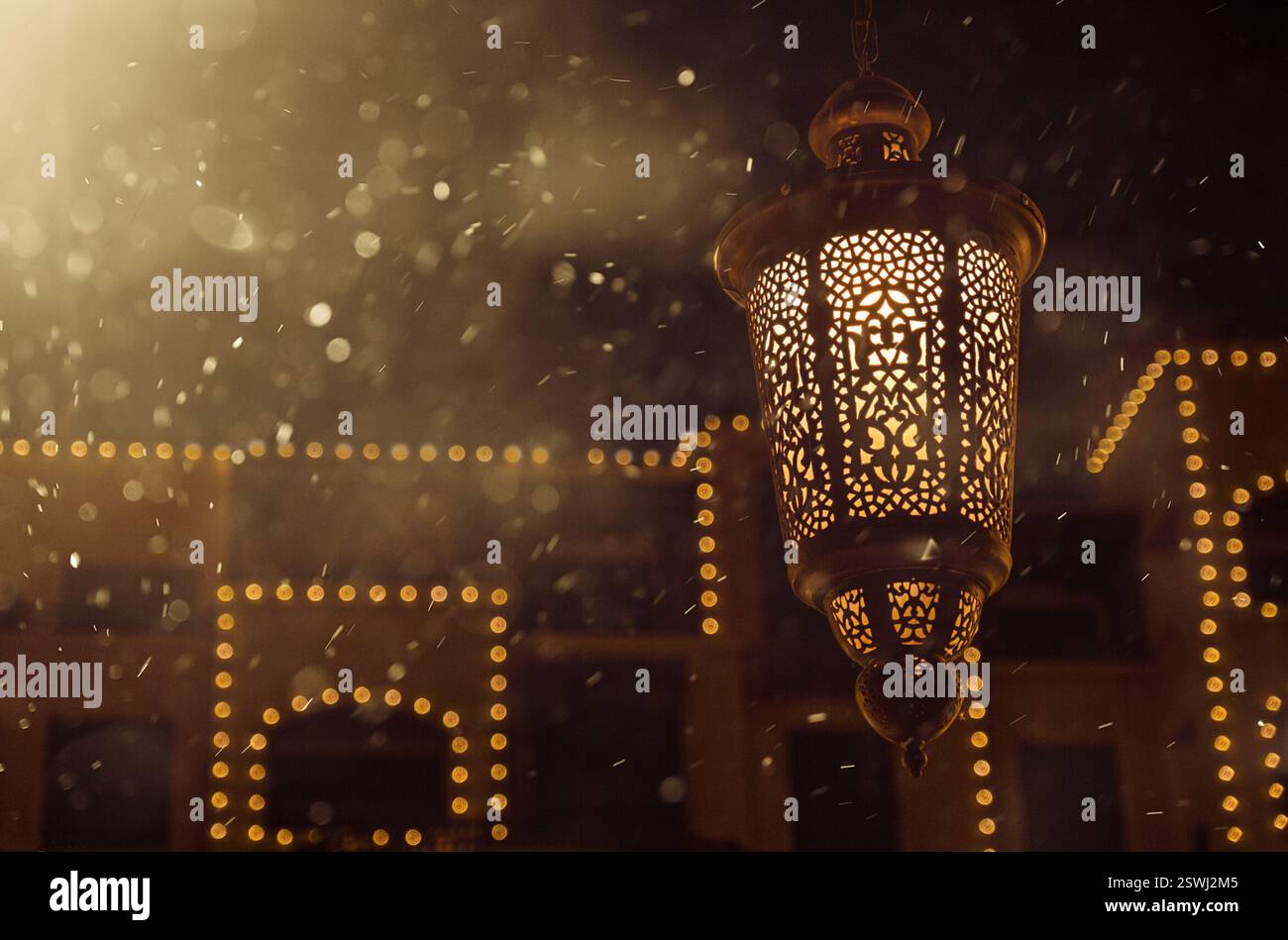 Ornamental Arabic lantern glowing at night and glittering golden bokeh ...