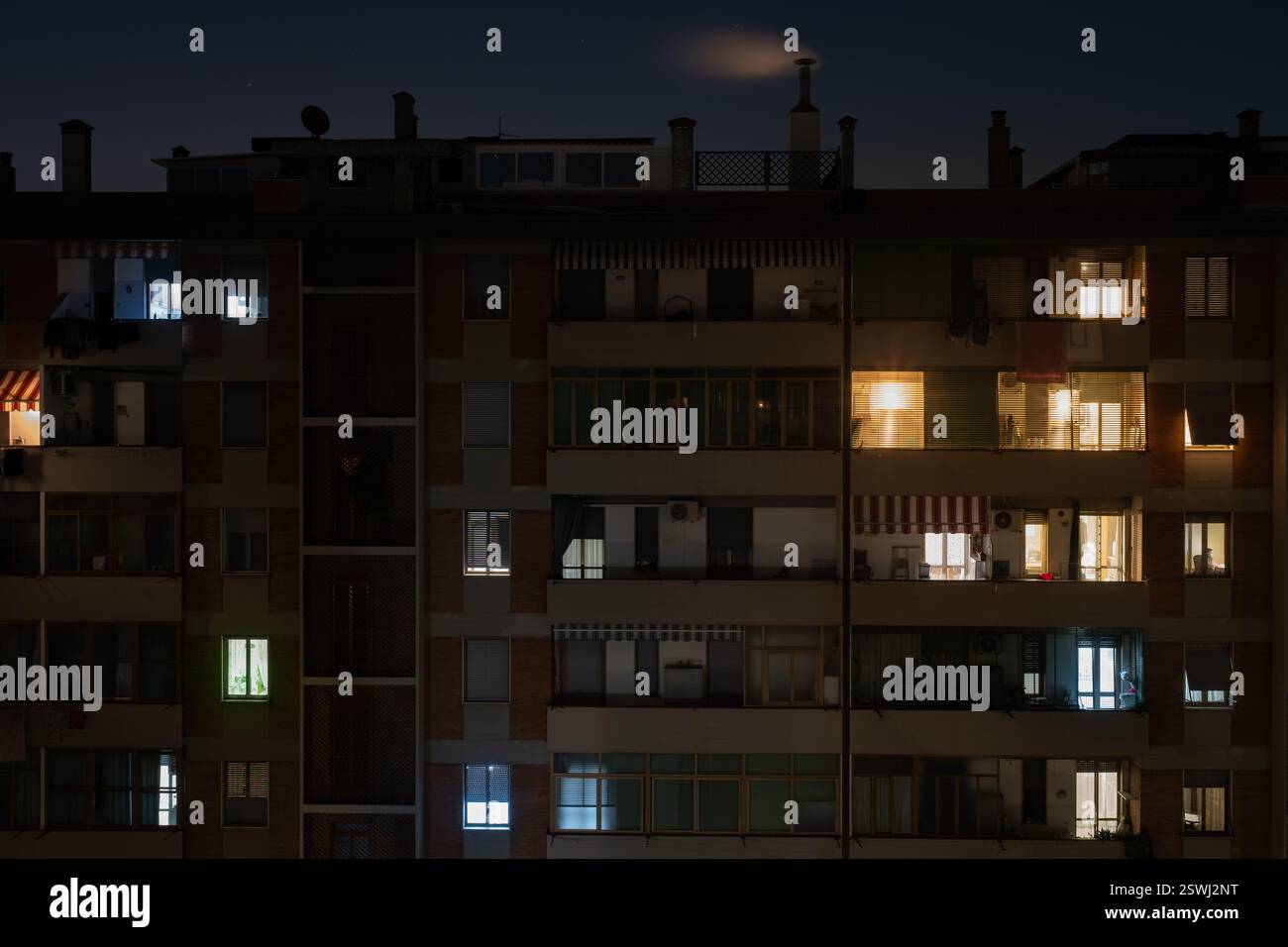 View of the main facade of a city apartment building. The night is dark ...
