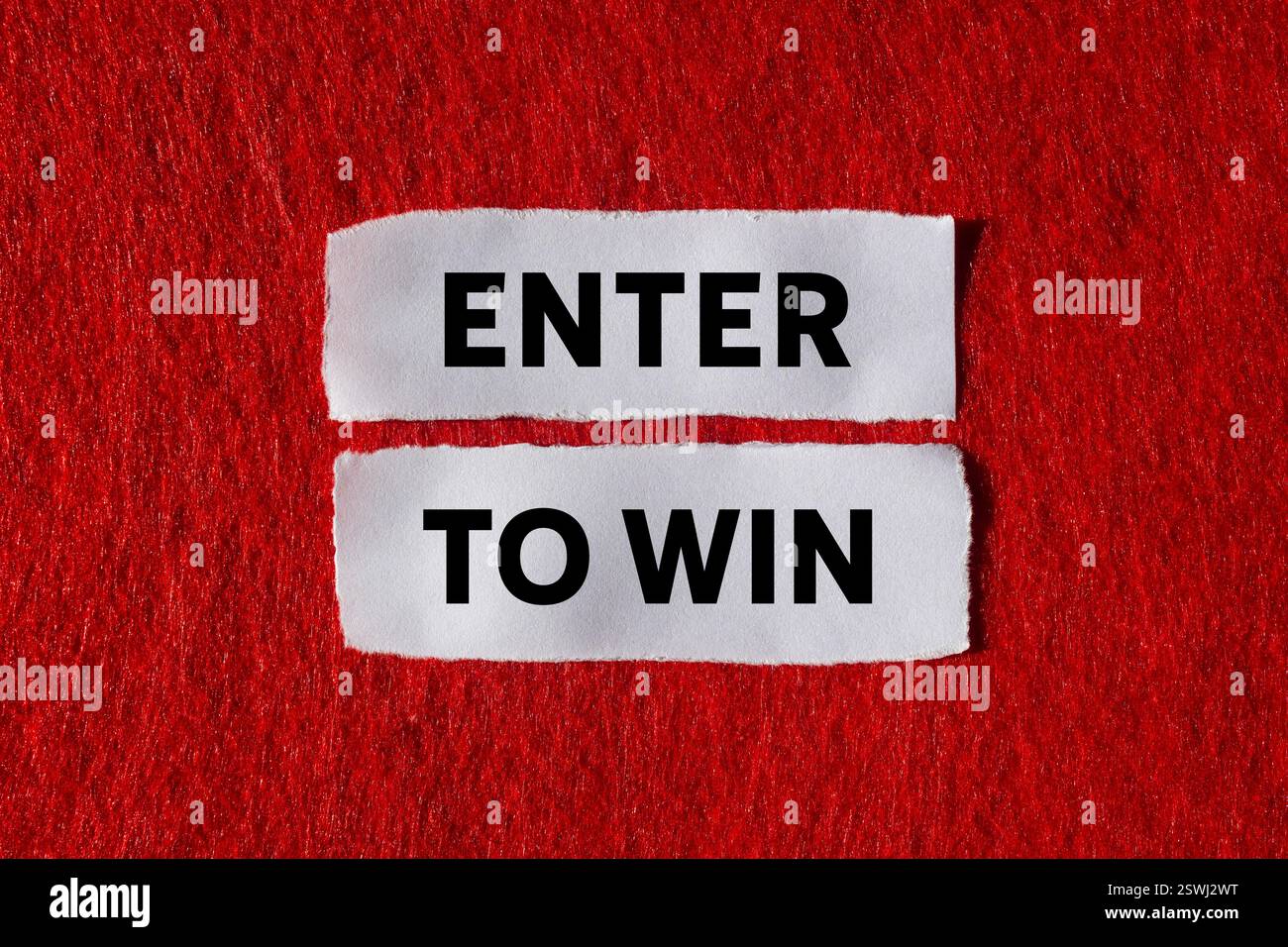 Enter to win message written on ripped torn paper pieces on red ...