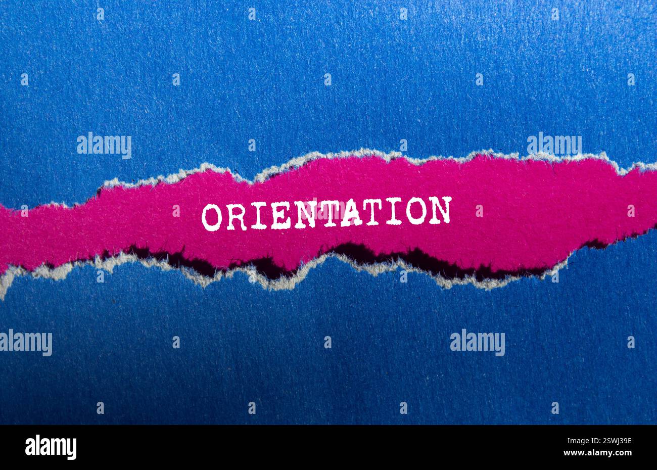 Orientation message written on ripped torn blue paper on pink ...