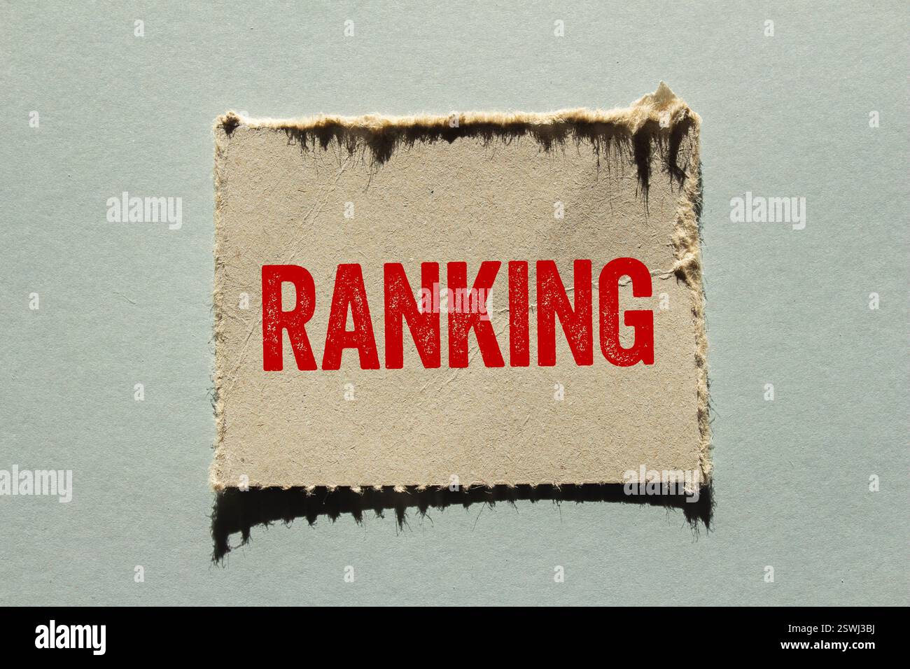 Ranking message written on ripped torn paper piece on gray background ...