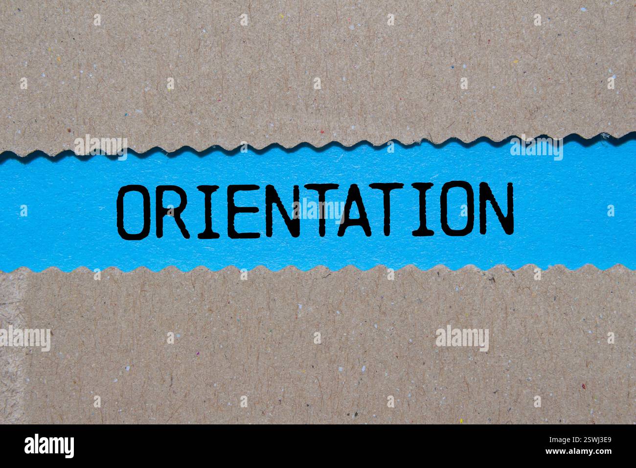 Orientation message written on ripped torn paper on blue background ...