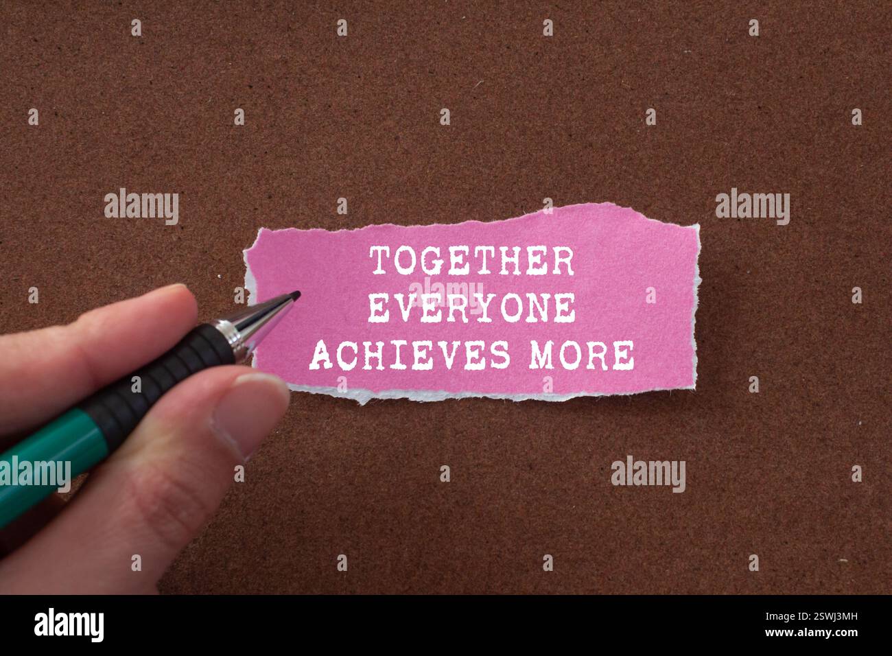 Together everyone achieves more message written on ripped torn pink ...