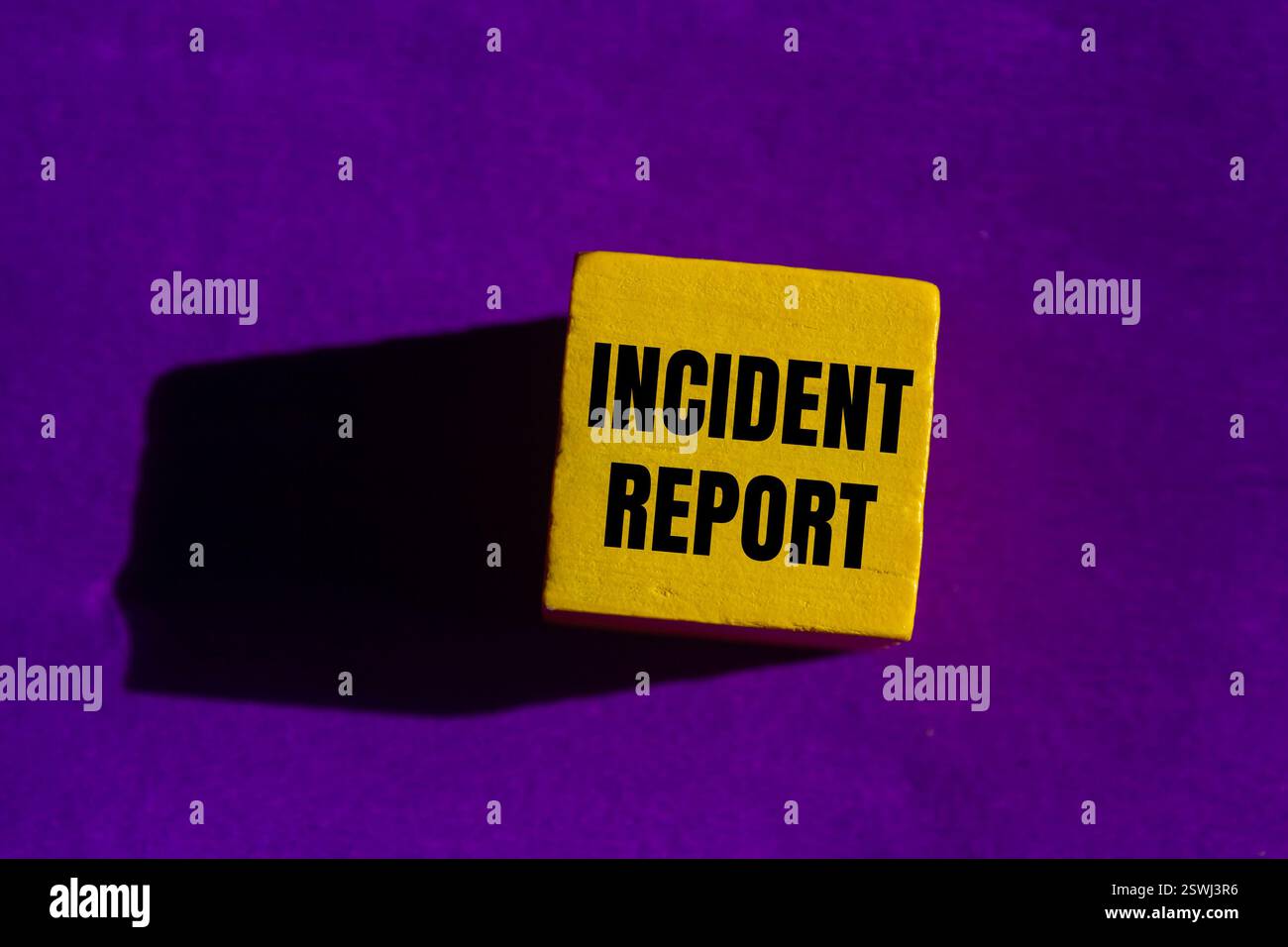 Incident report message written on yellow wooden cube on purple ...