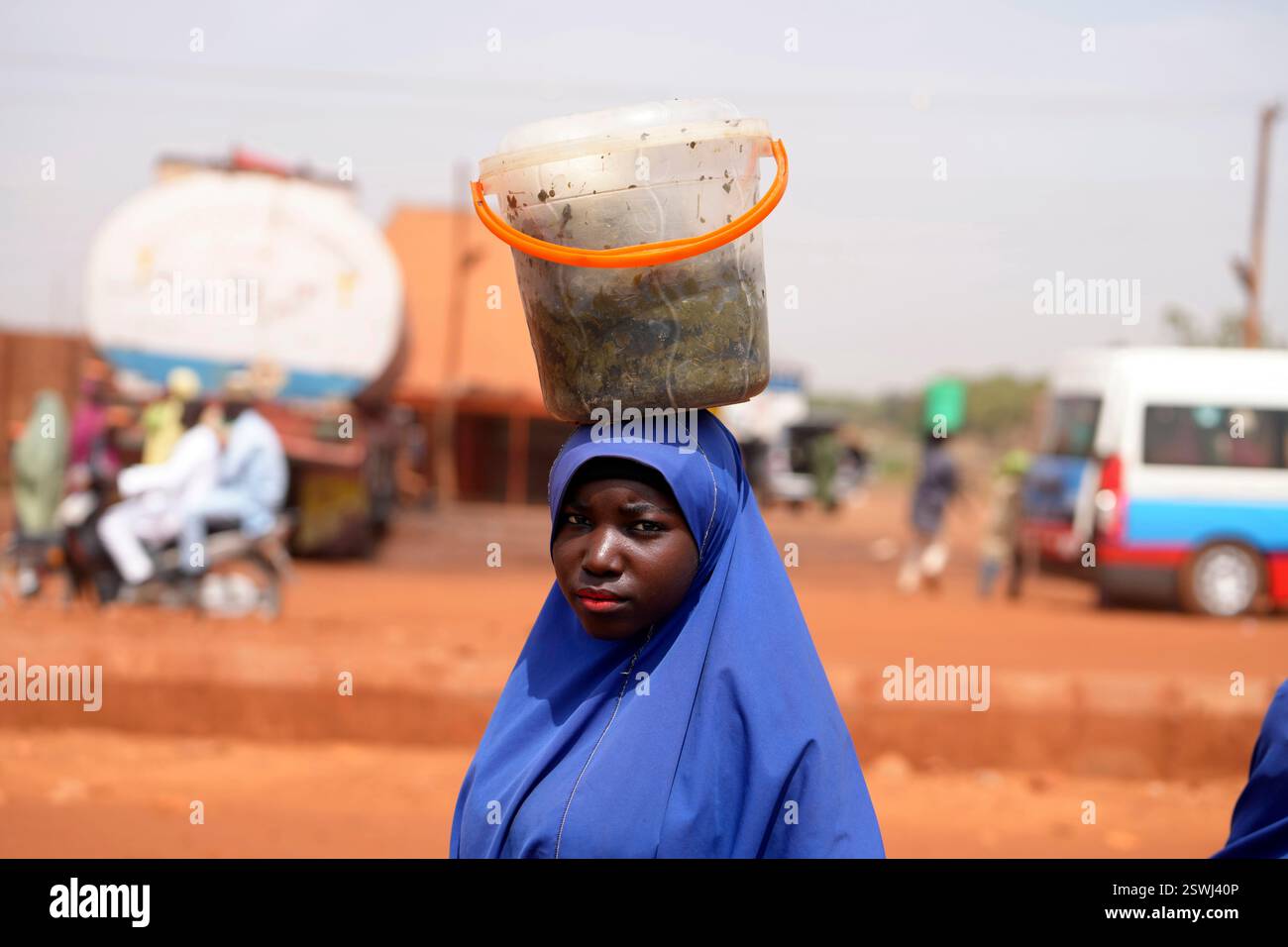 A woman sells cooked cabbage leaves on a road side market in Sokoto ...