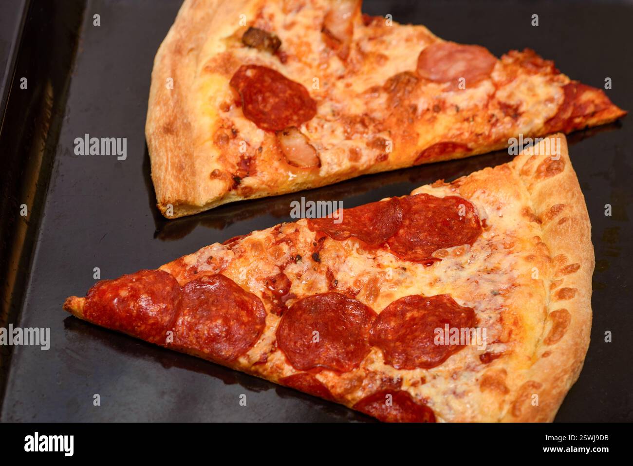 Two slices of freshly cooked pizza on a baking sheet. Fast food Stock ...