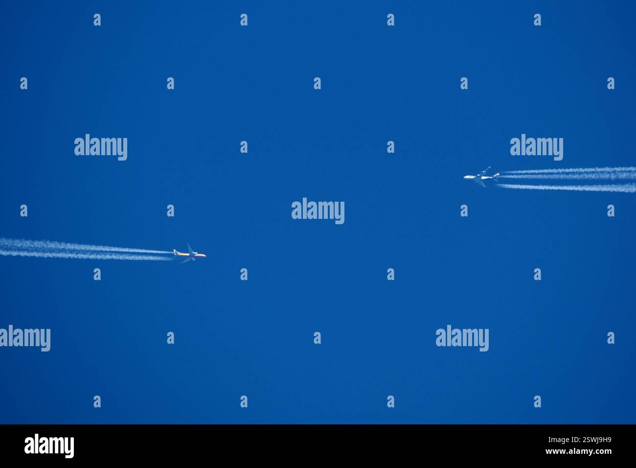 Two airplanes flying in the blue sky. Airplane in the blue sky with ...