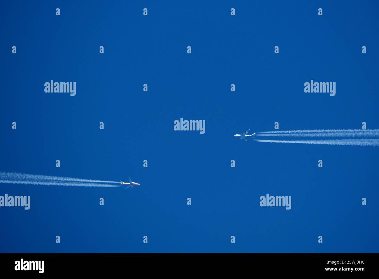 Two airplanes flying in the blue sky. Airplane in the blue sky with ...