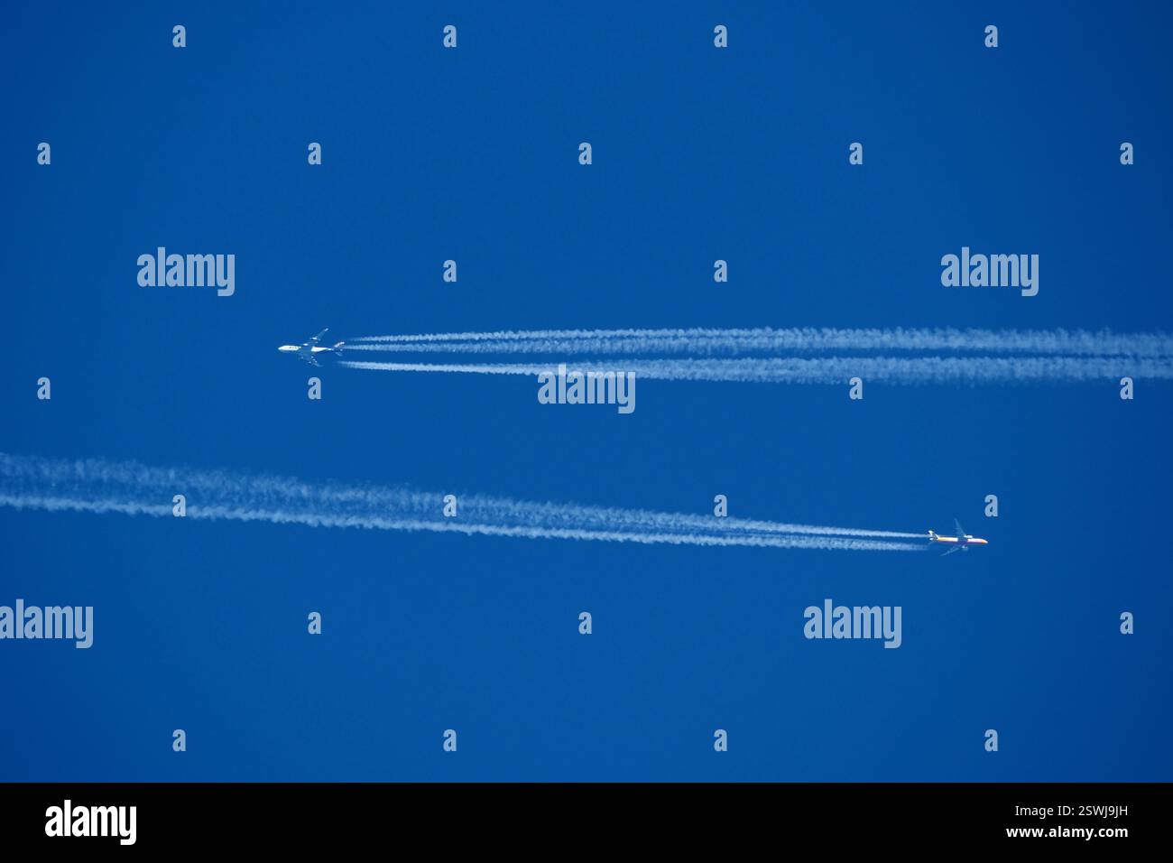 Two airplanes flying in the blue sky. Airplane in the blue sky with ...