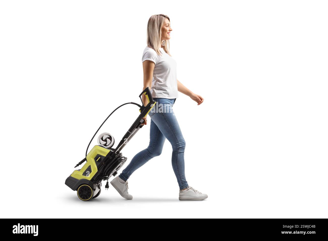 Young woman walking and pulling a high pressure washer machine isolated ...