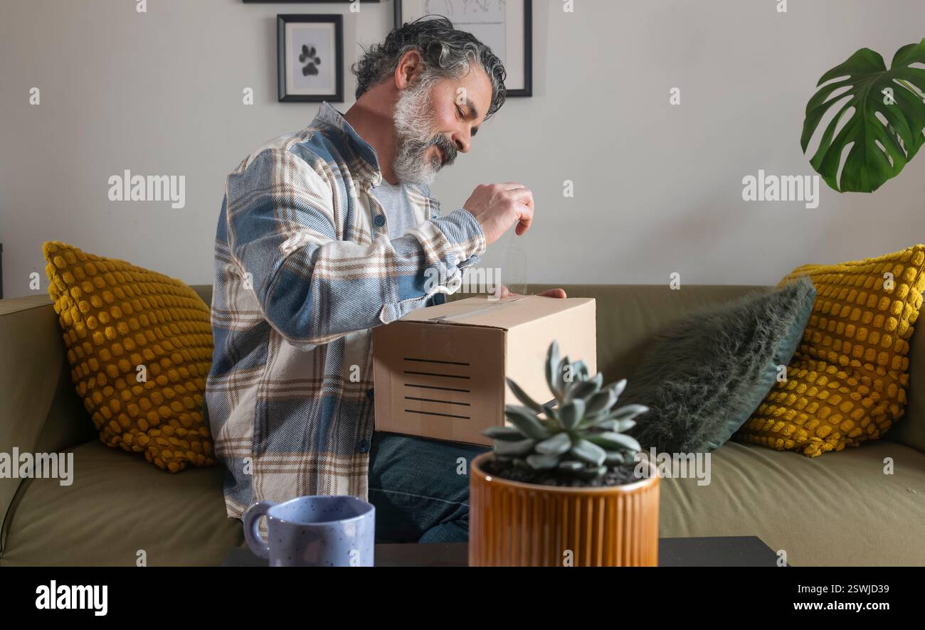 Happy customer opening parcel at home after online shopping Stock Photo ...