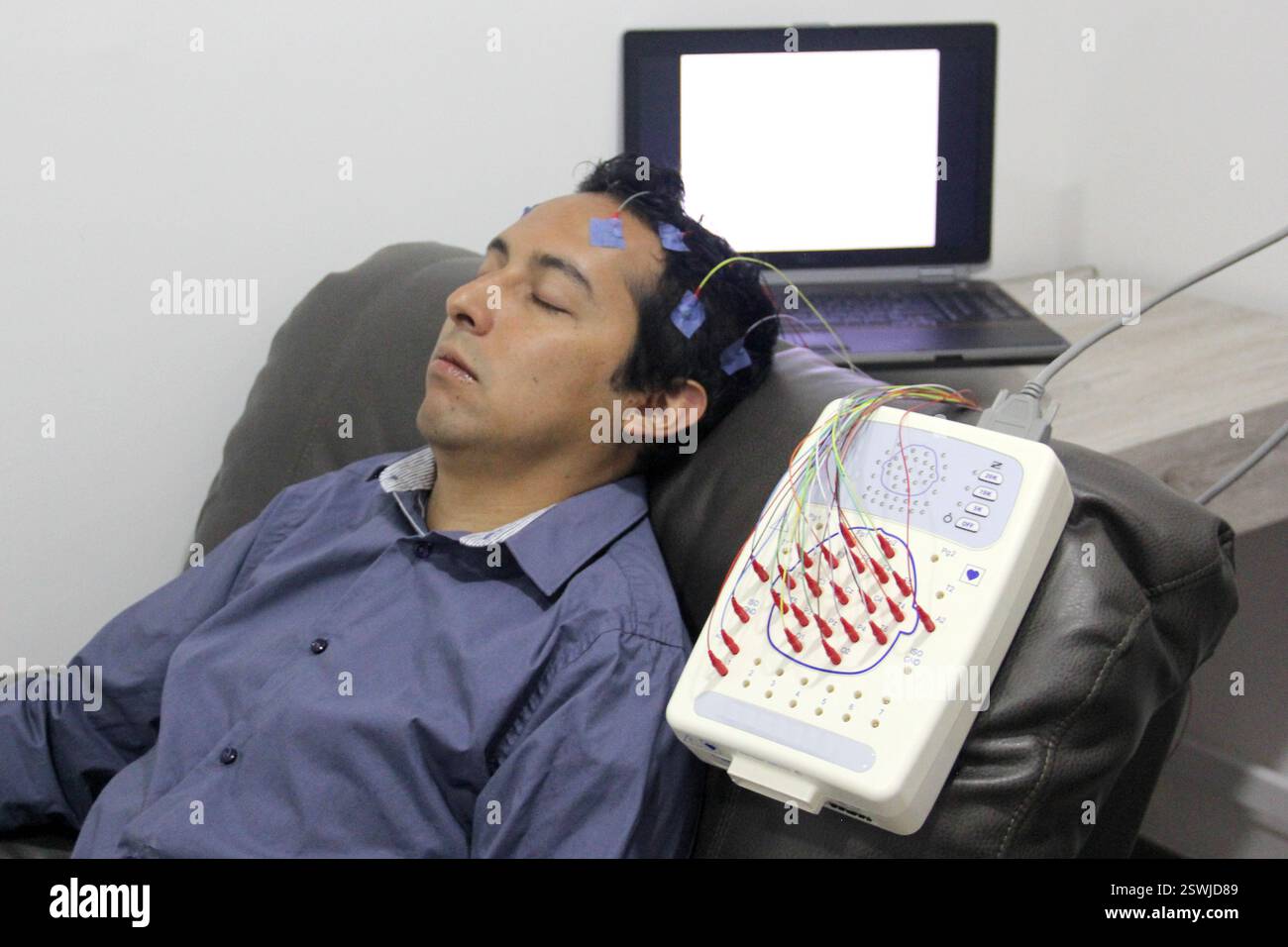 Electroencephalogram EEG in adult Latino man with wires in his head ...