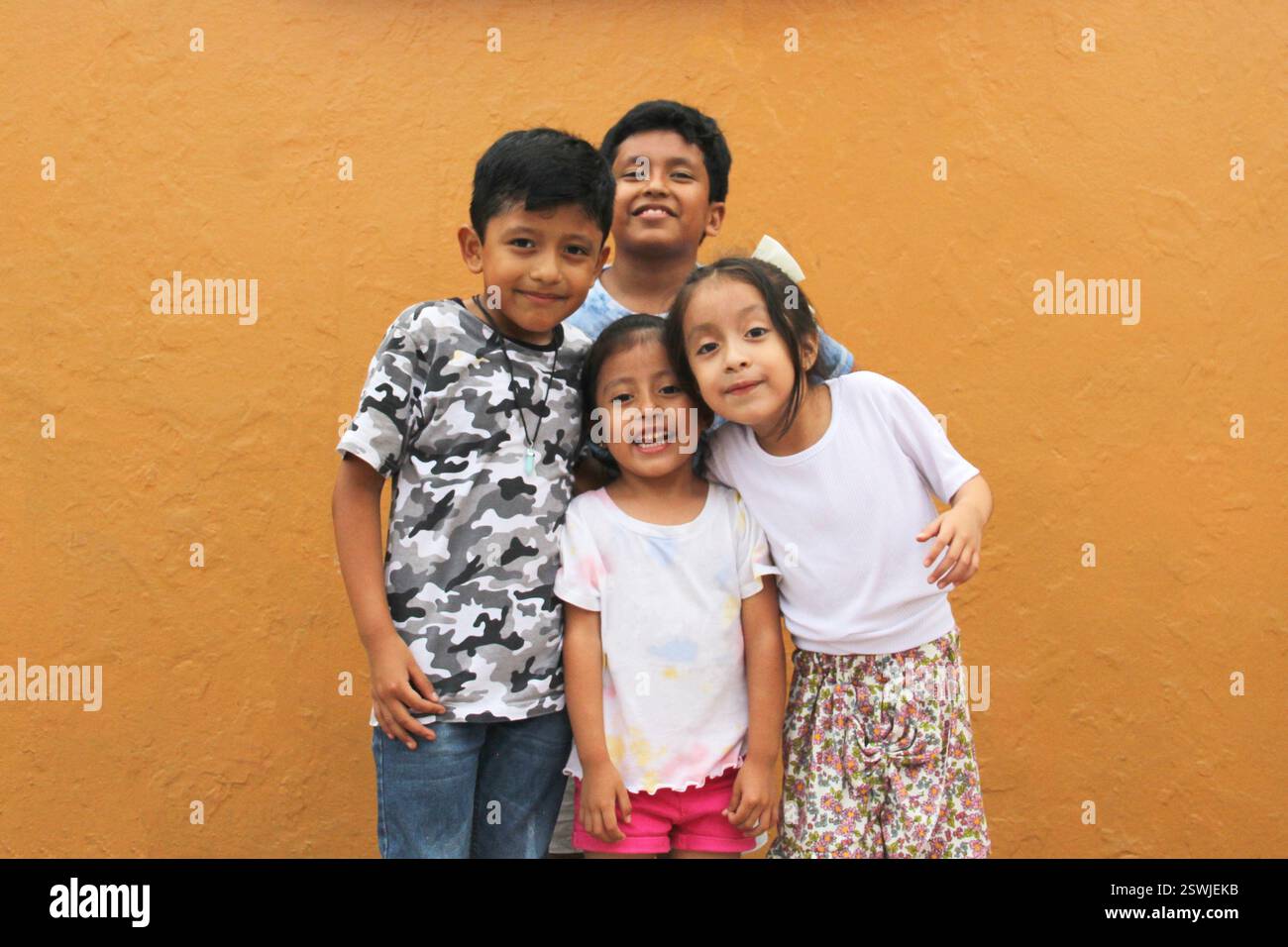 Two happy and excited dark-skinned Latino boys and 2 girls celebrate ...