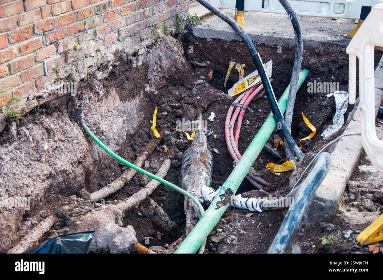 Utility workers are excavating and working on underground utility lines ...