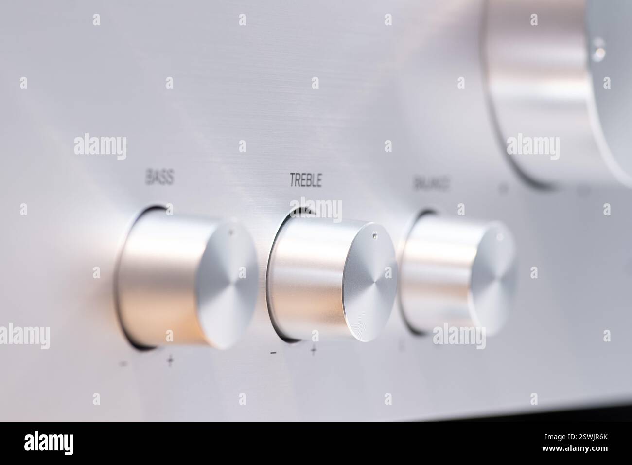 Detailed view of an audio amplifier's control knobs for bass, treble ...