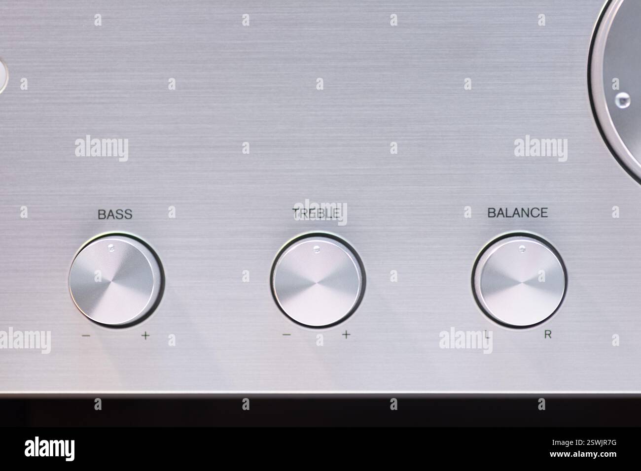 Detailed view of an audio amplifier's control knobs for bass, treble ...