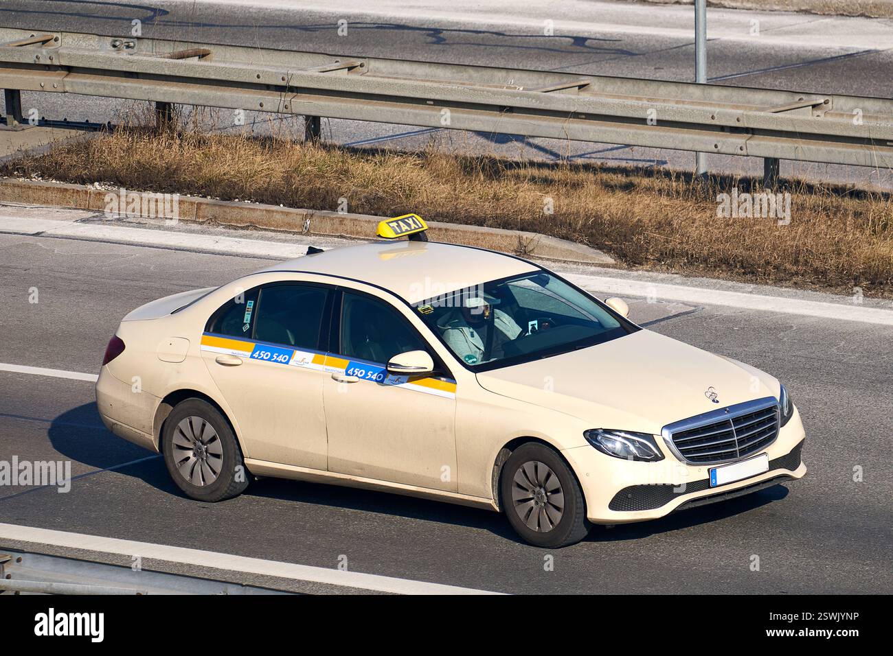 Munich, Bavaria, Germany - February 20, 2025: A cab drives on a road ...