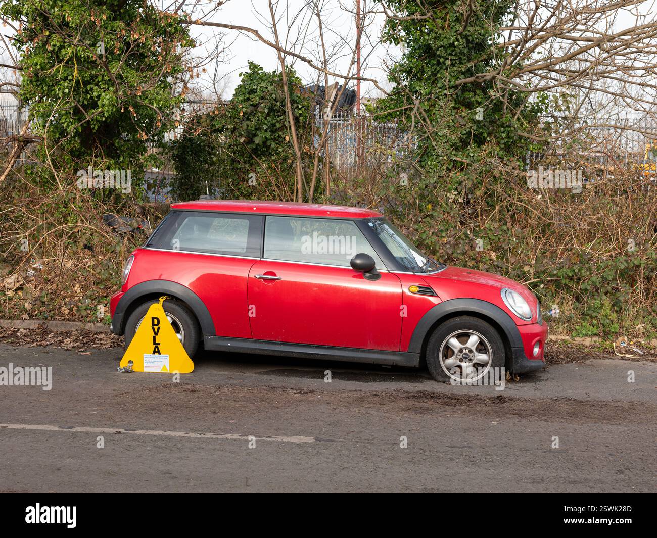 DVLA wheel clamp fitted to Mini car in the UK Stock Photo - Alamy