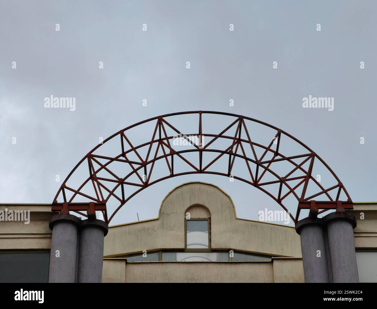 Architectural Contrast: Metal Arch & Concrete Pillars Stock Photo - Alamy