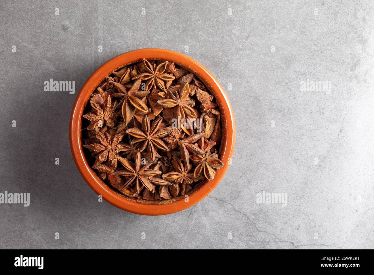 A clay bowl full of Anis on a kitchen countertop in a zenithal ...