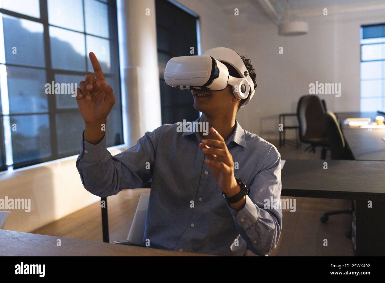 In office, man using VR headset and interacting with virtual ...