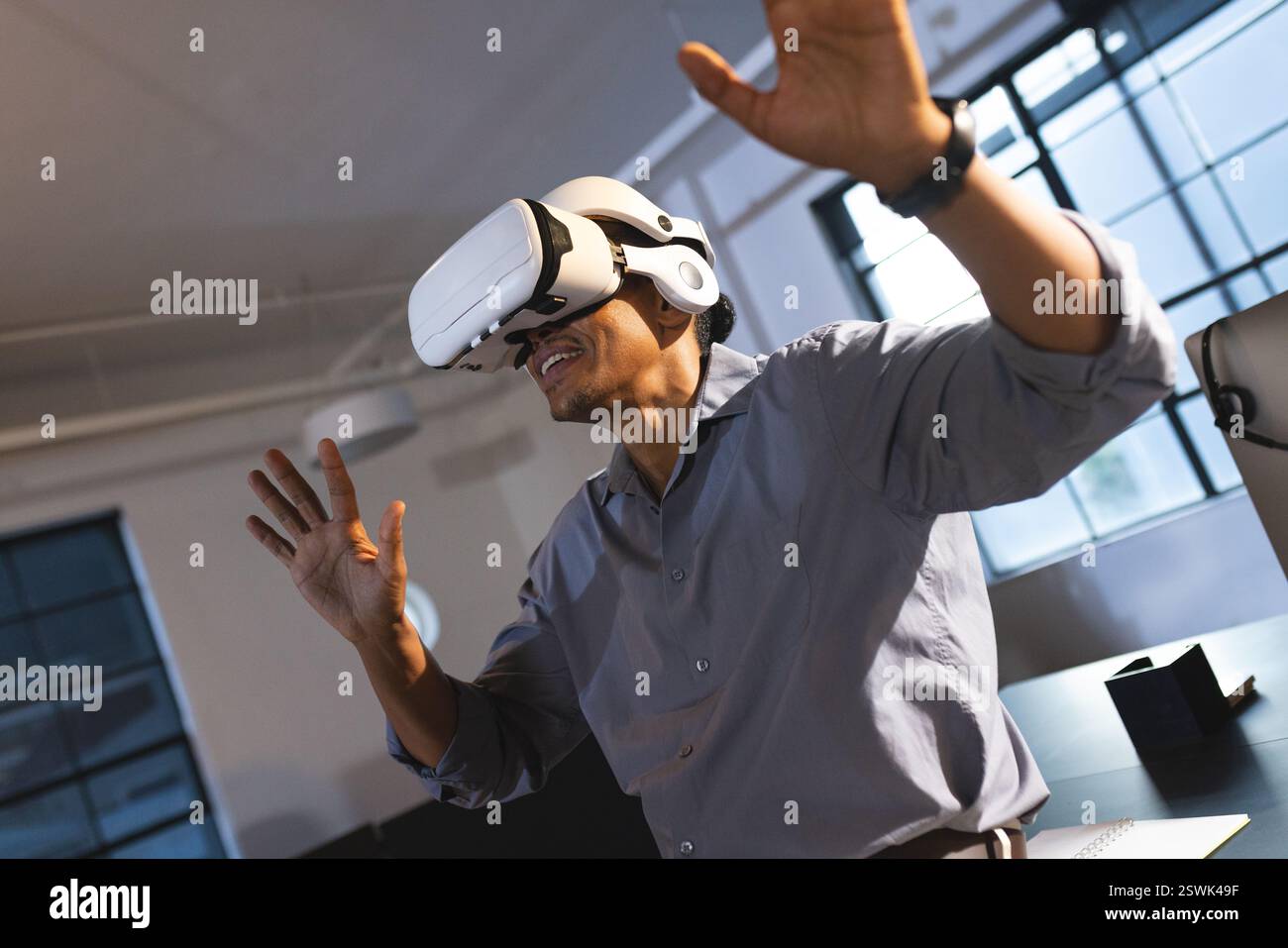 Man using VR headset in office, experiencing virtual reality with ...