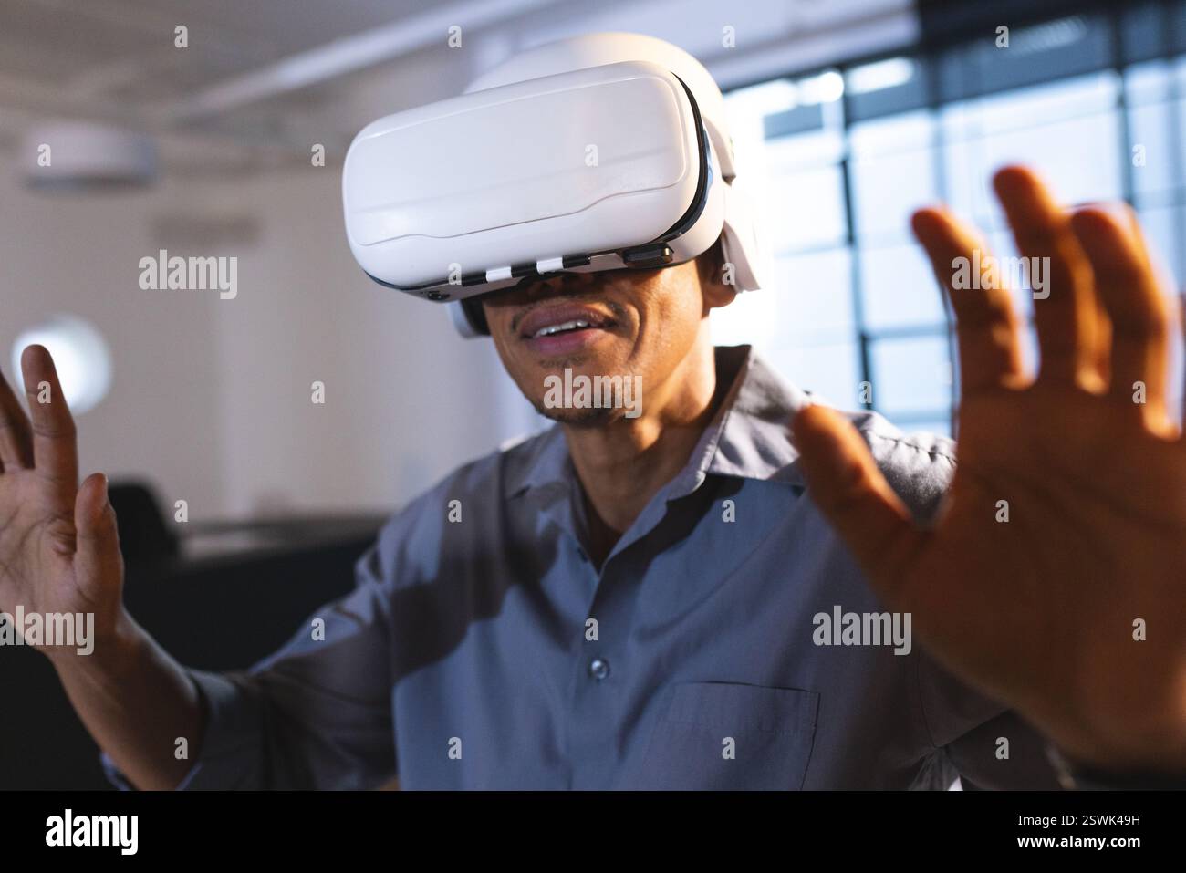 Man using VR headset in office, exploring virtual reality with hands ...