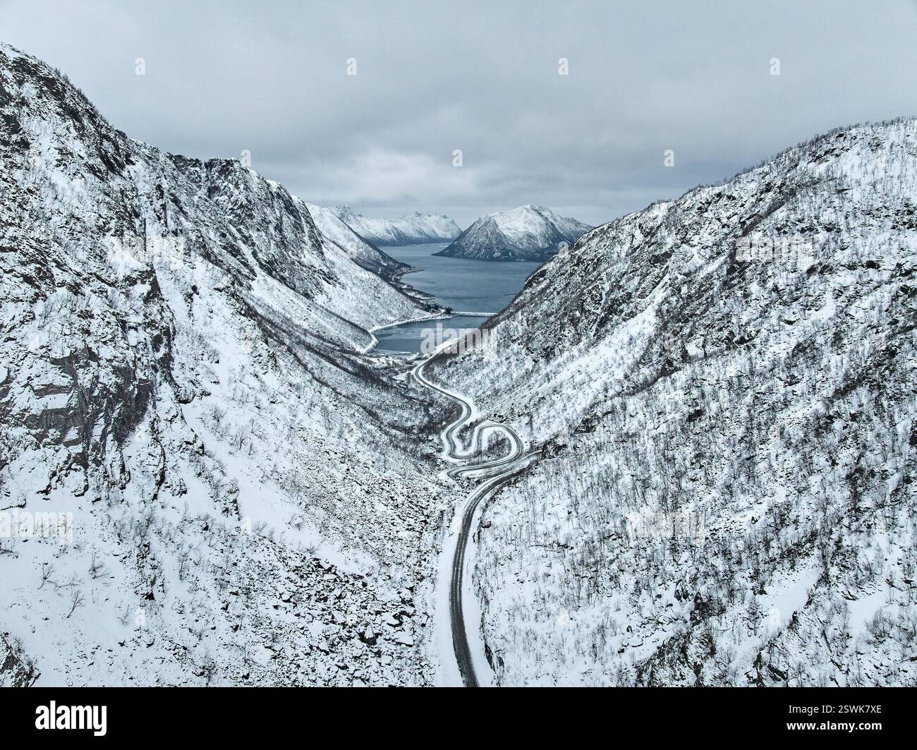 aerial photo of a snowy winding mountain pass road down to Sifjord on ...
