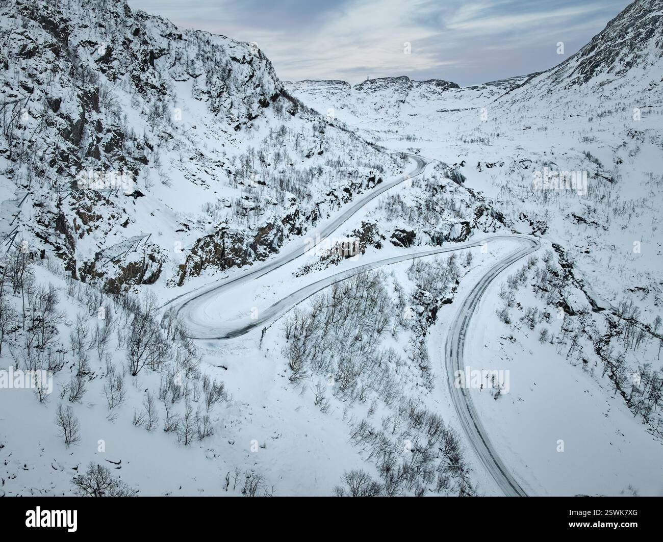 aerial photo of a snowy winding mountain pass road down to Sifjord on ...