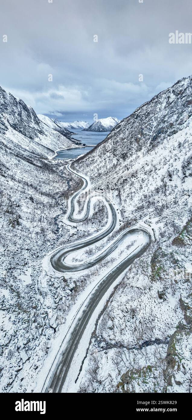 aerial photo of a snowy winding mountain pass road down to Sifjord on ...
