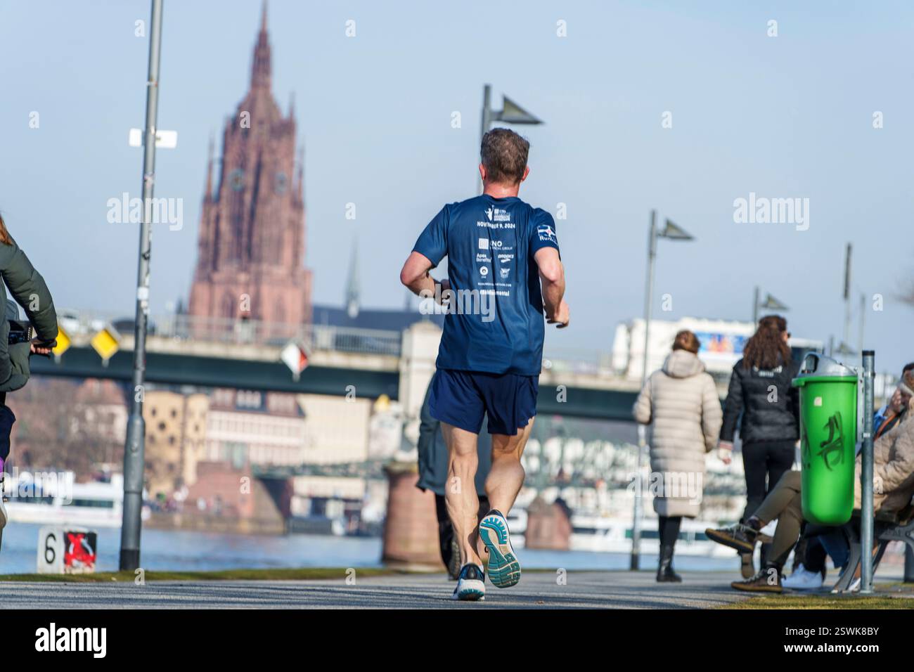 21 February 2025, Hesse, Frankfurt/Main: A man jogs along the banks of ...